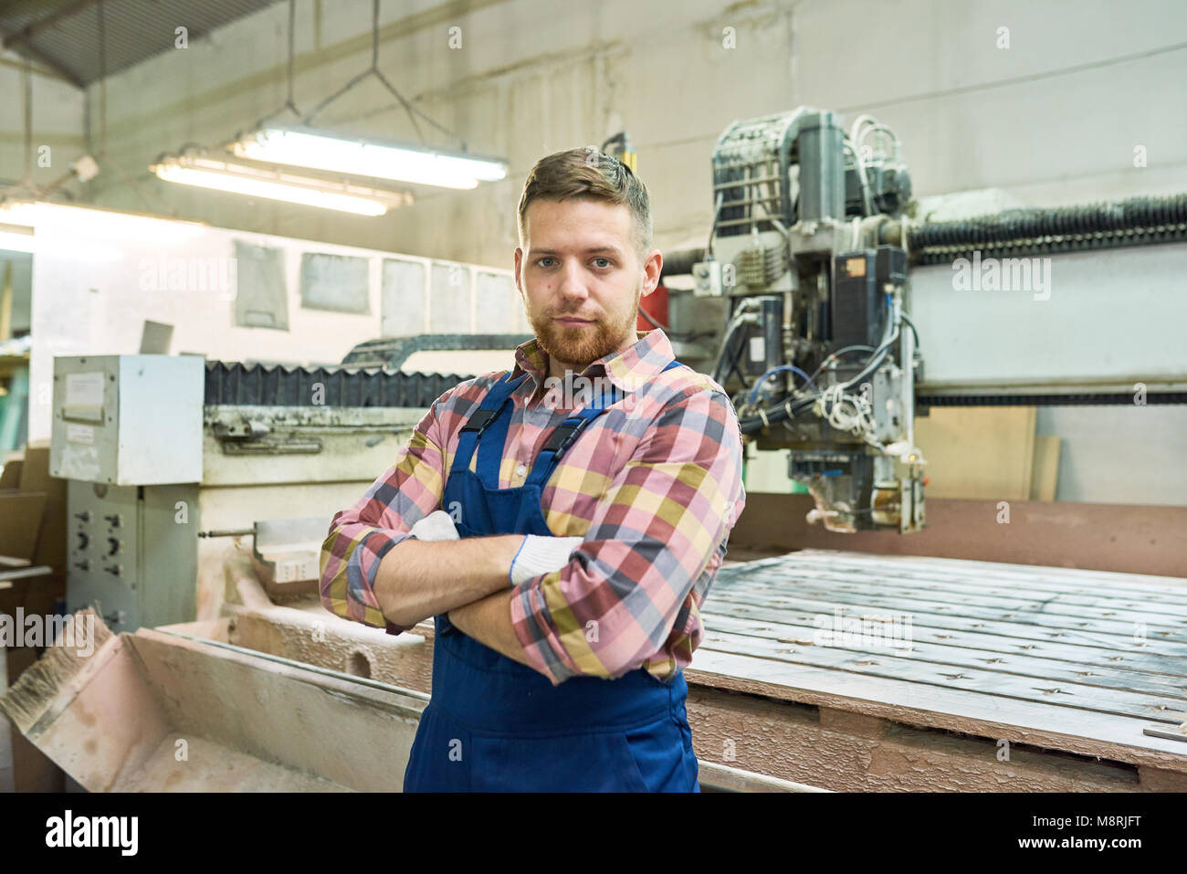 Young Factory Worker Posing in Workshop Stock Photo - Alamy