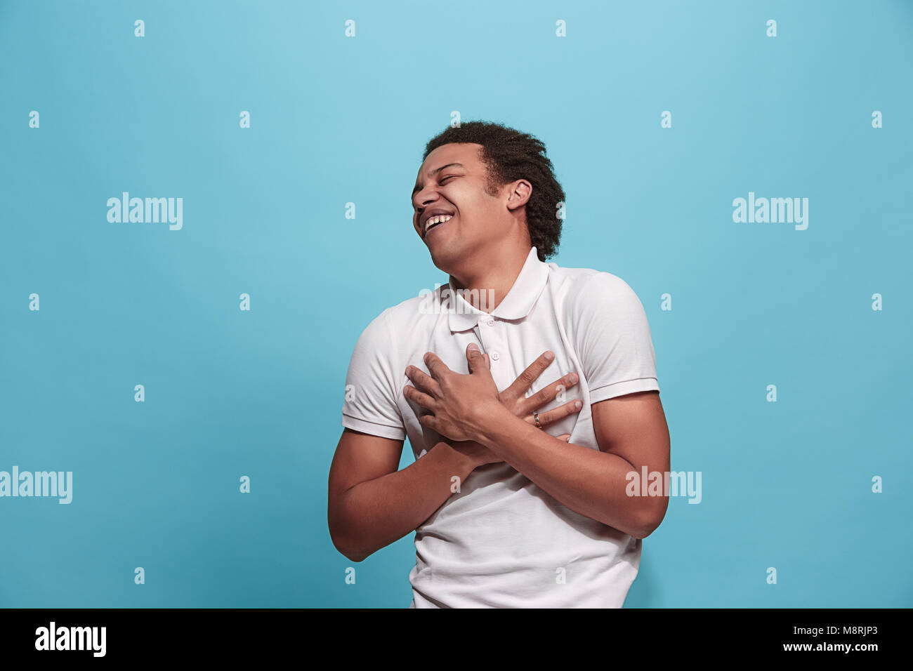 The happy business man standing and smiling against blue background ...