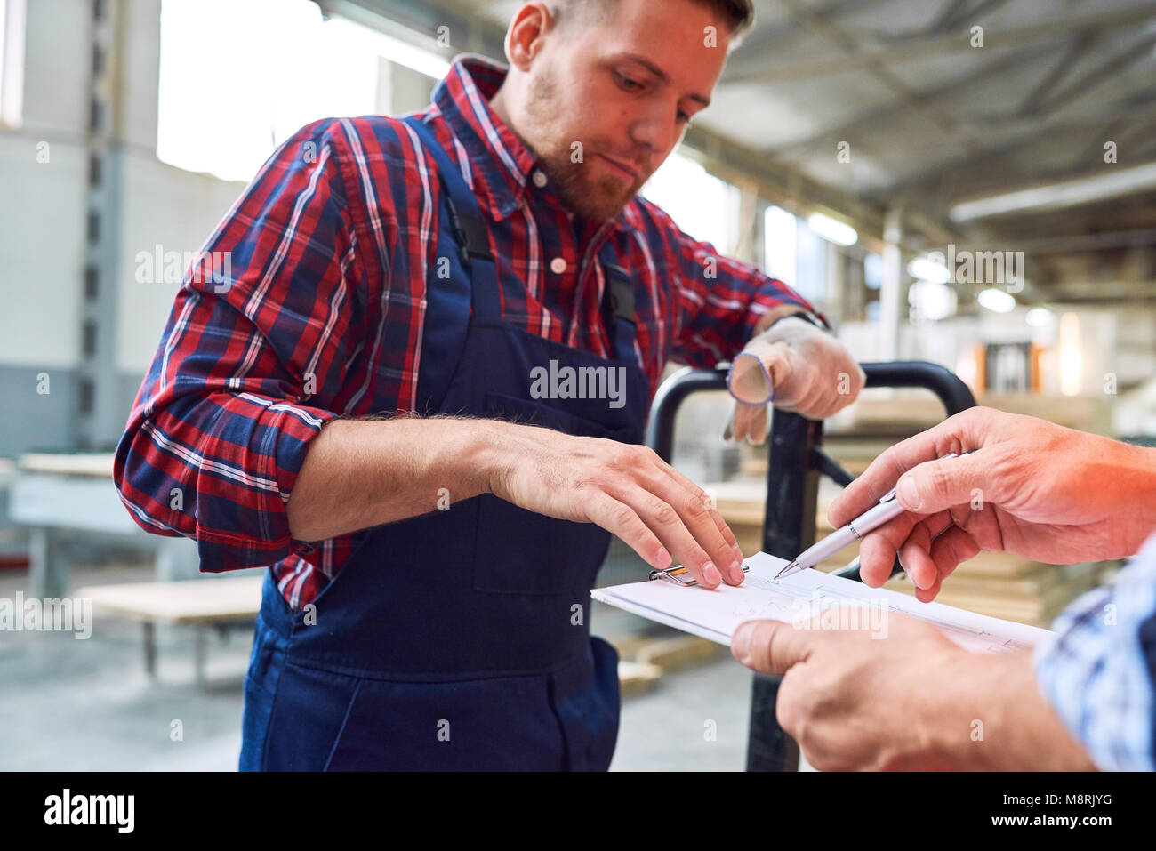 Worker Signing Shipments Order in Warehouse Stock Photo - Alamy