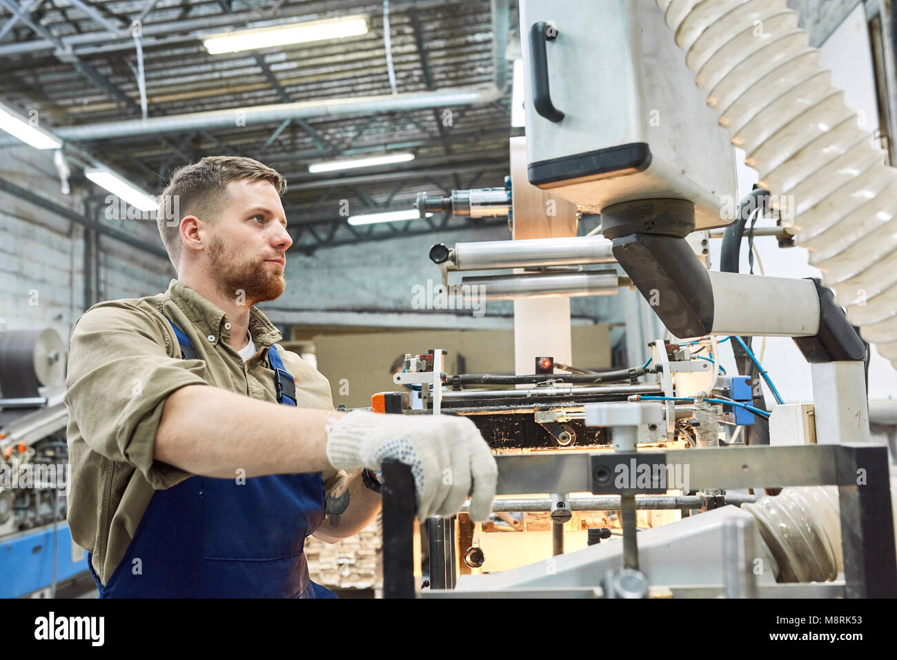 Young Factory Workers Operating Machine Stock Photo - Alamy