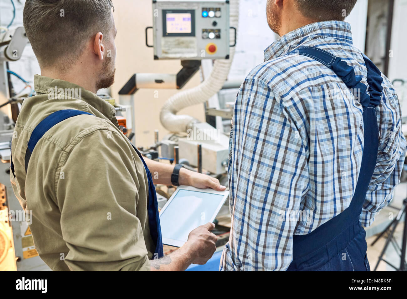 Two Factory Workers Operating Machine Units Stock Photo - Alamy
