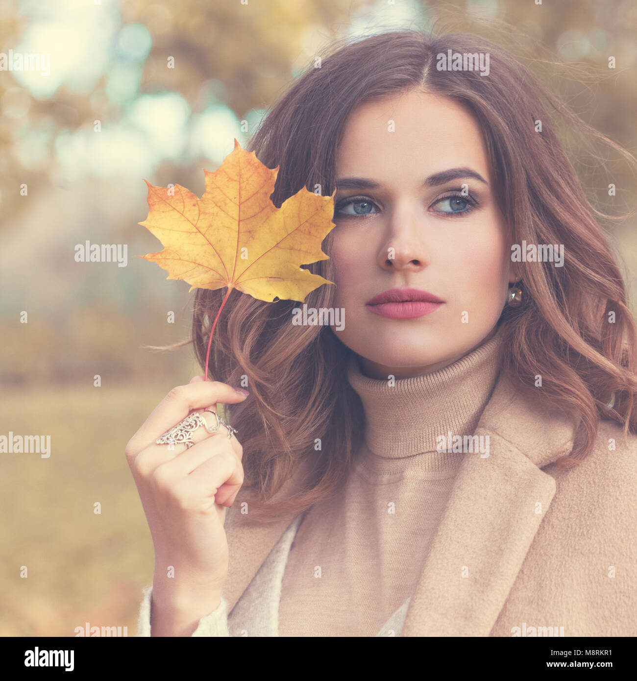 Autumn Fashion Model Woman with Wavy Hair and Fall Mapple Leaf Outdoors ...