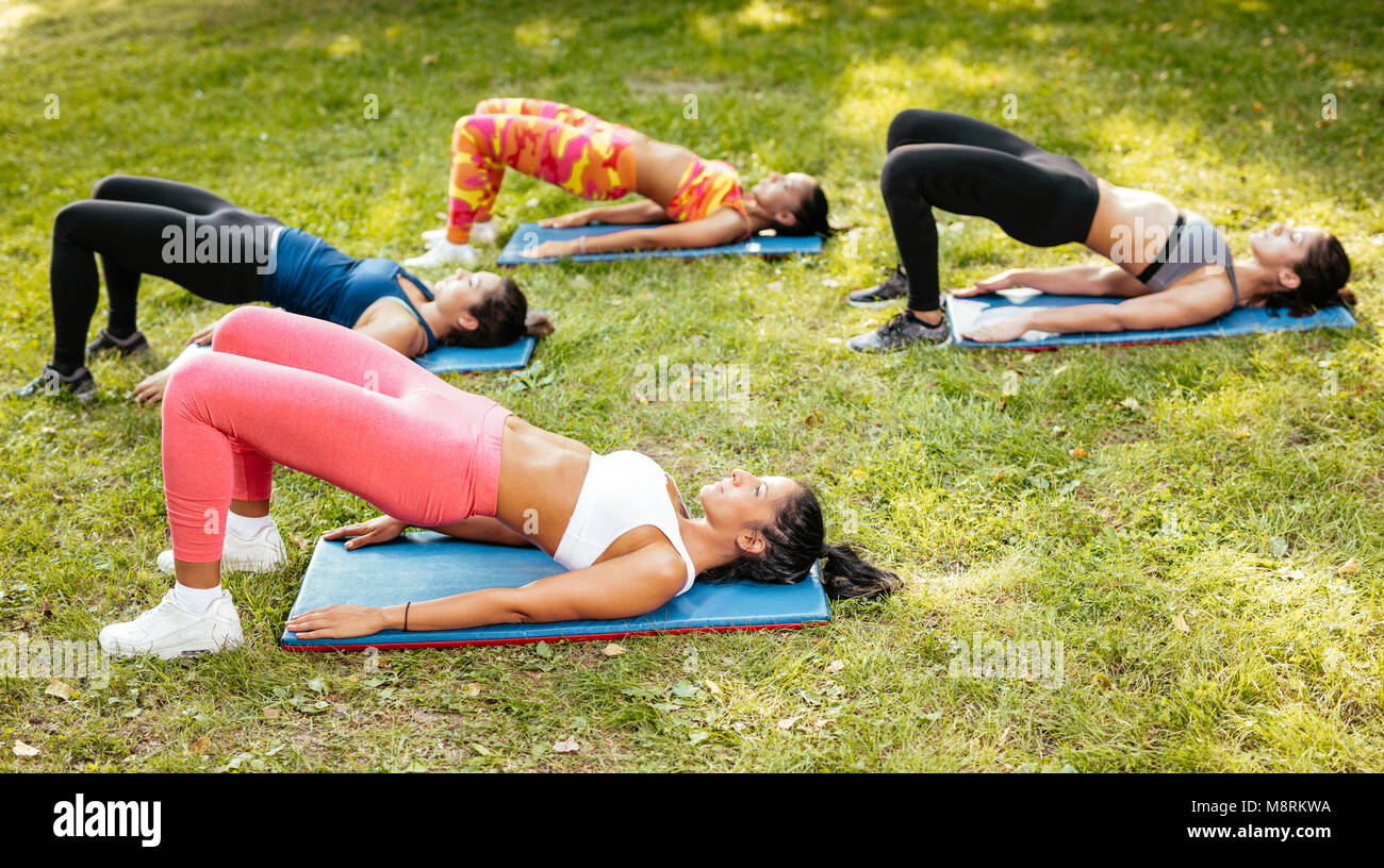 Group of four young health athletic girls doing stretching exercise in ...