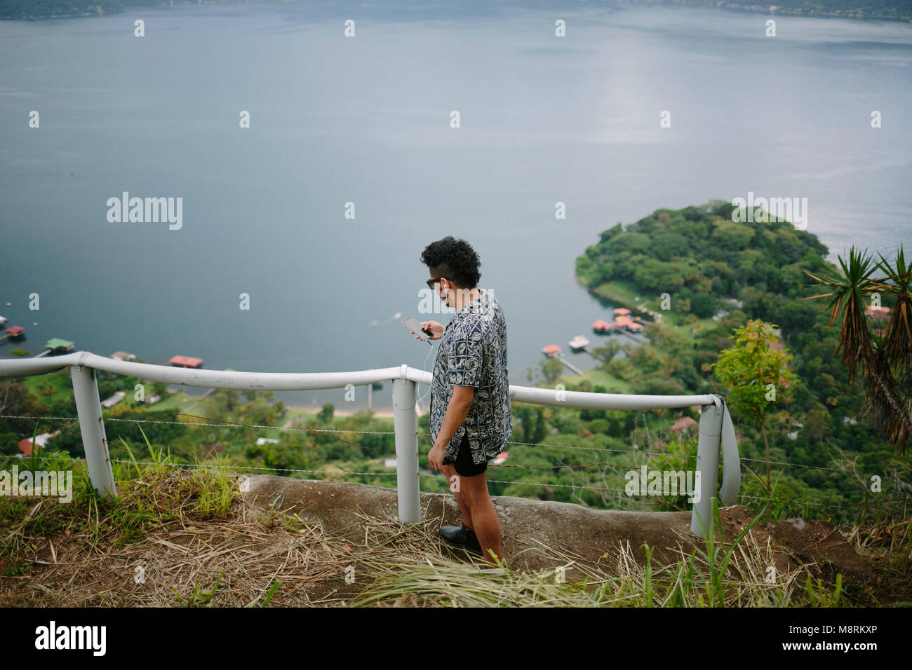 Side view of man using mobile phone while standing at observation point ...