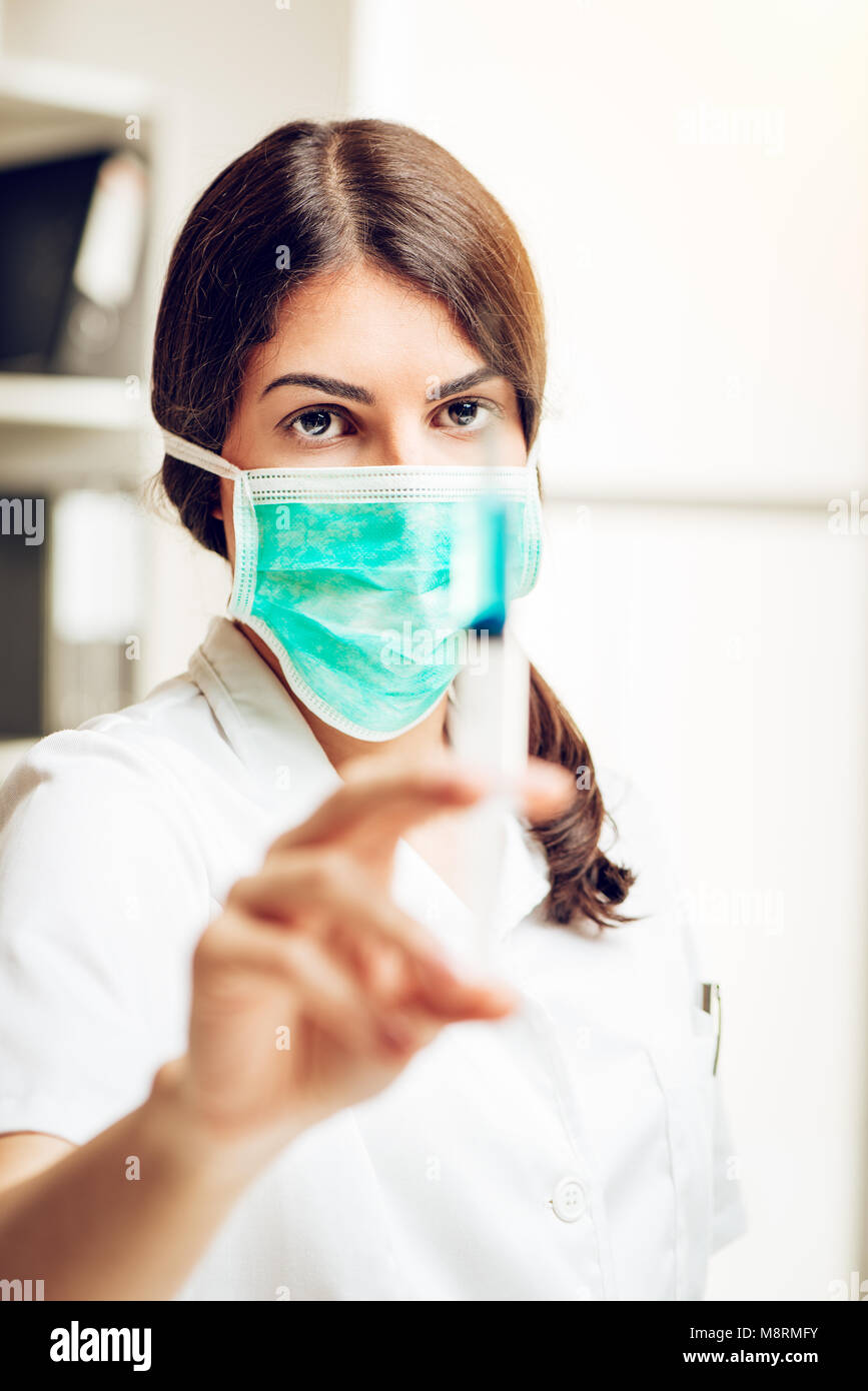 Young female nurse standing in her consulting room and preparing an ...