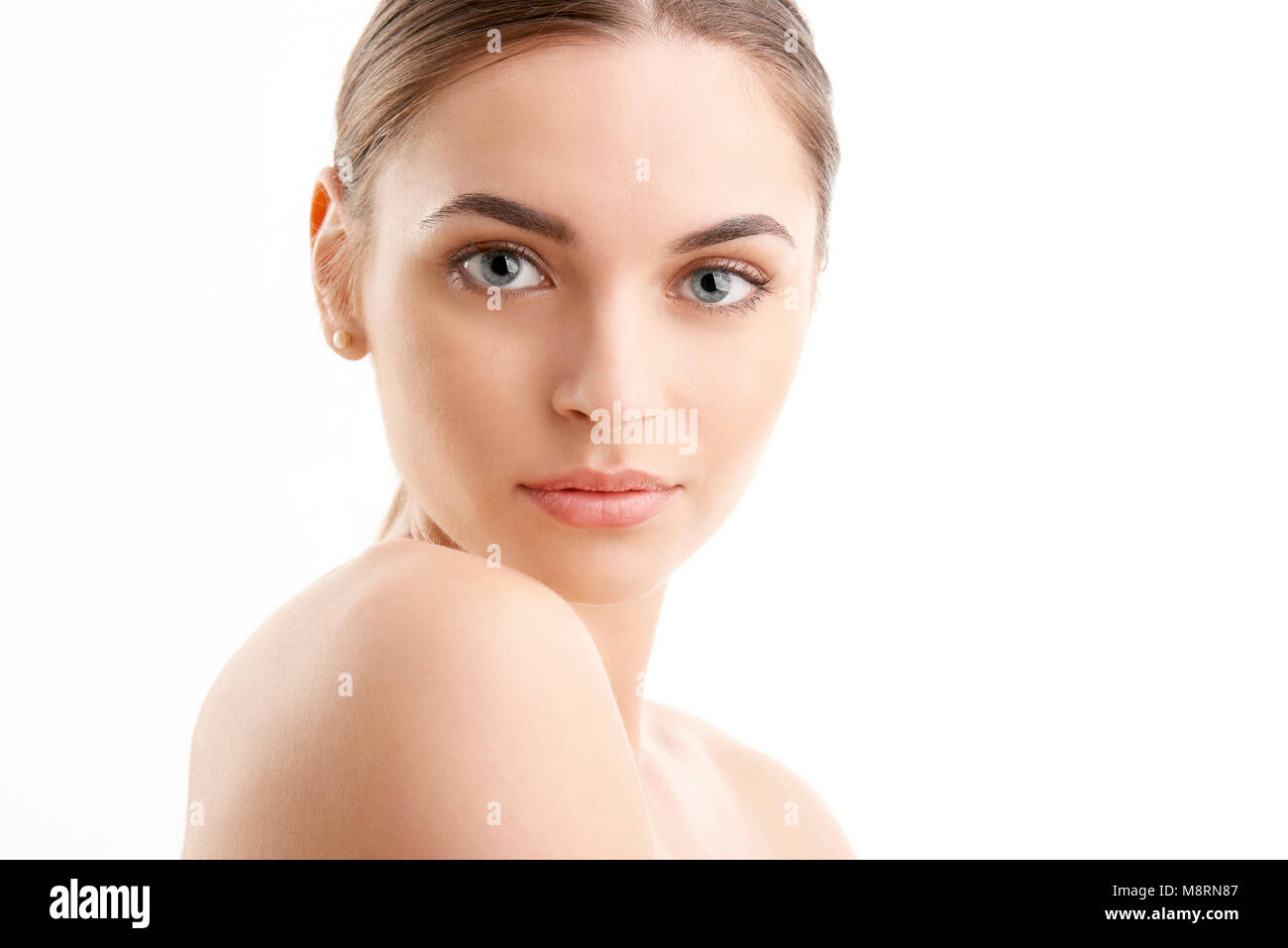 Portrait of a beautiful young woman looking at camera and posing at ...