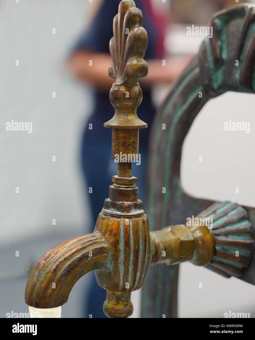 Public metal yellow faucet fountain with drinking water flowing in old ...