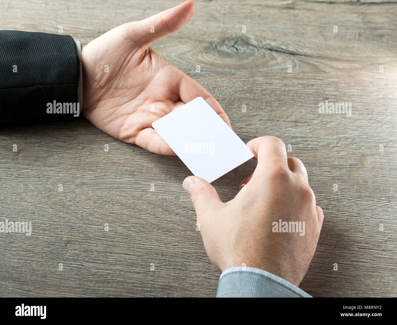 Business man giving business card to business partner with wooden table ...