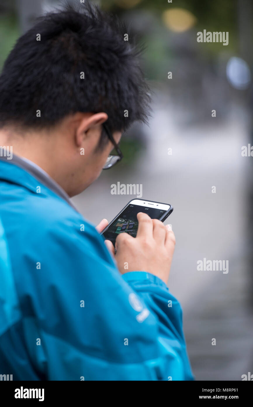 Man using a mobile phone on the streets of Shanghai in China Stock ...