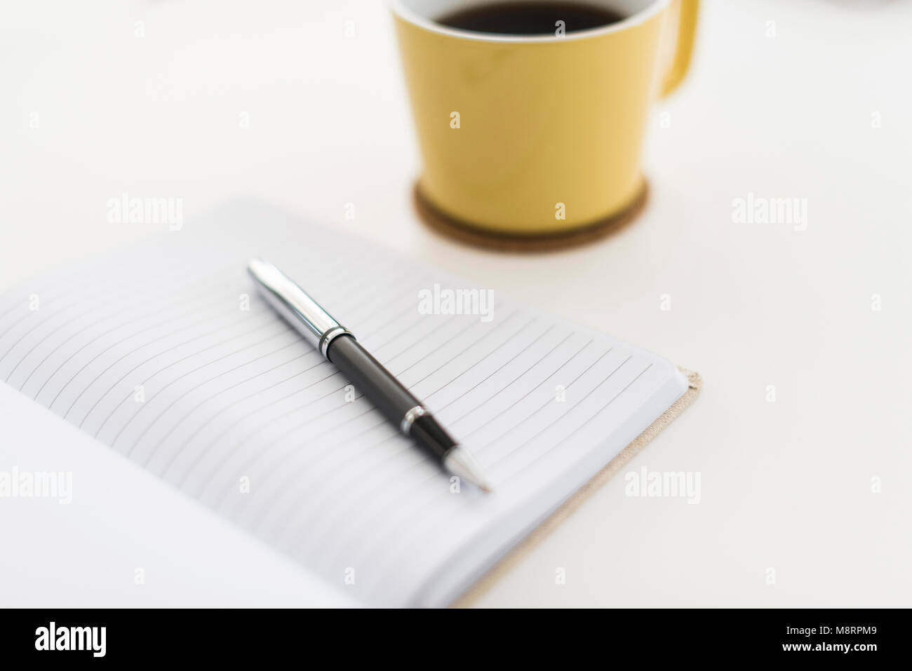 Close-up of book and pen by coffee cup on white background Stock Photo ...