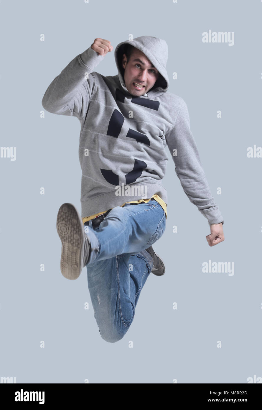 Funny cheerful happy man jumping in air over gray background Stock ...