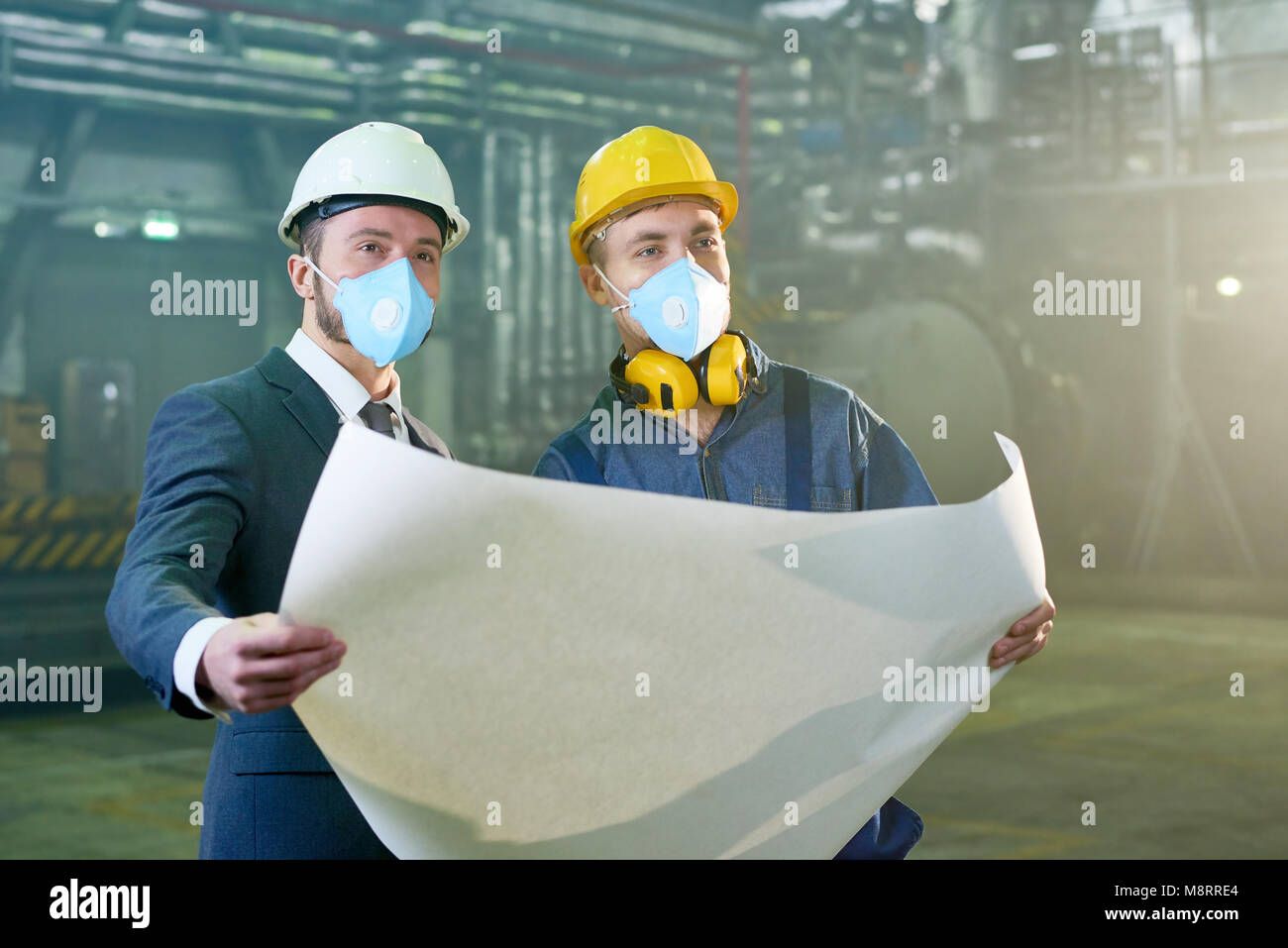 Engineers Holding Blueprints at Factory Stock Photo - Alamy