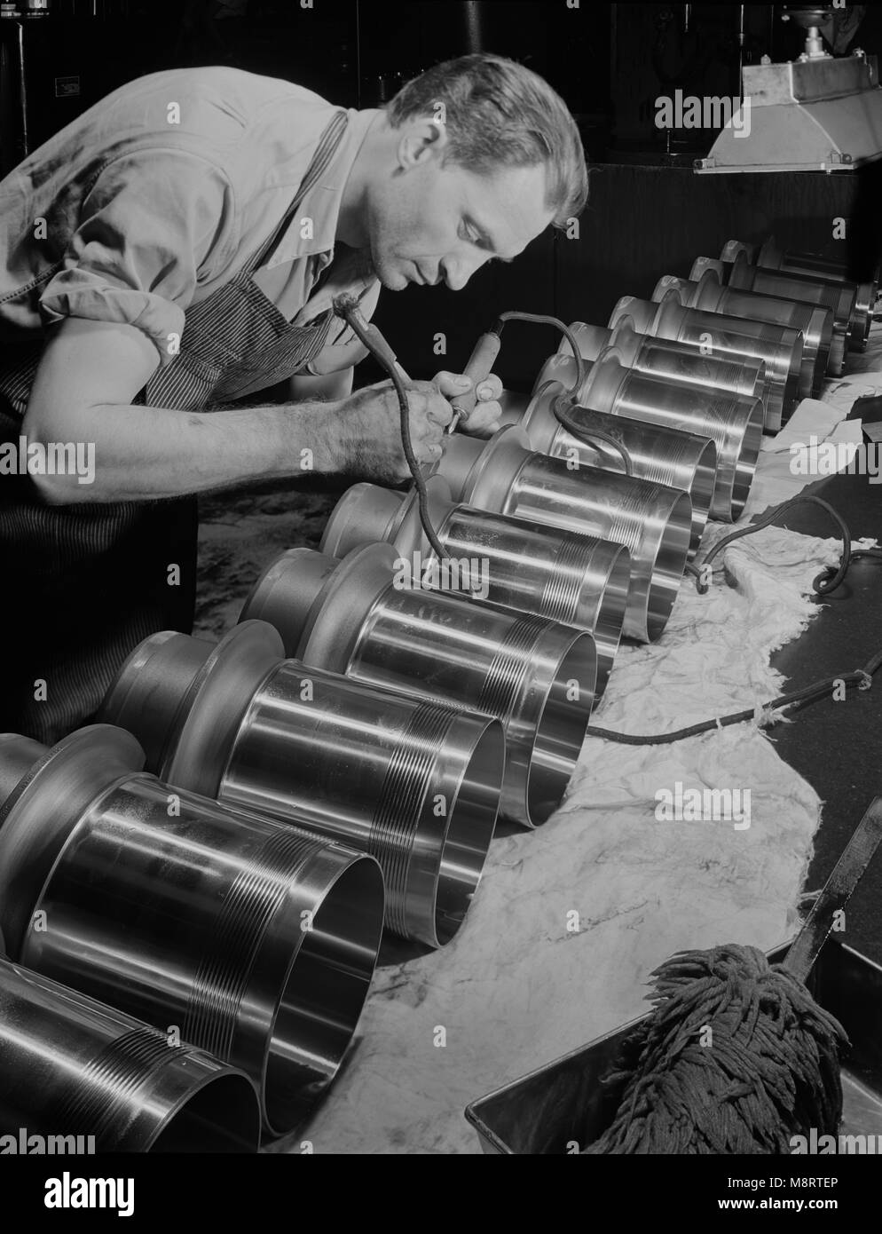 Worker Inspecting and Etching Cylinder Barrels for Airplane Engines at ...