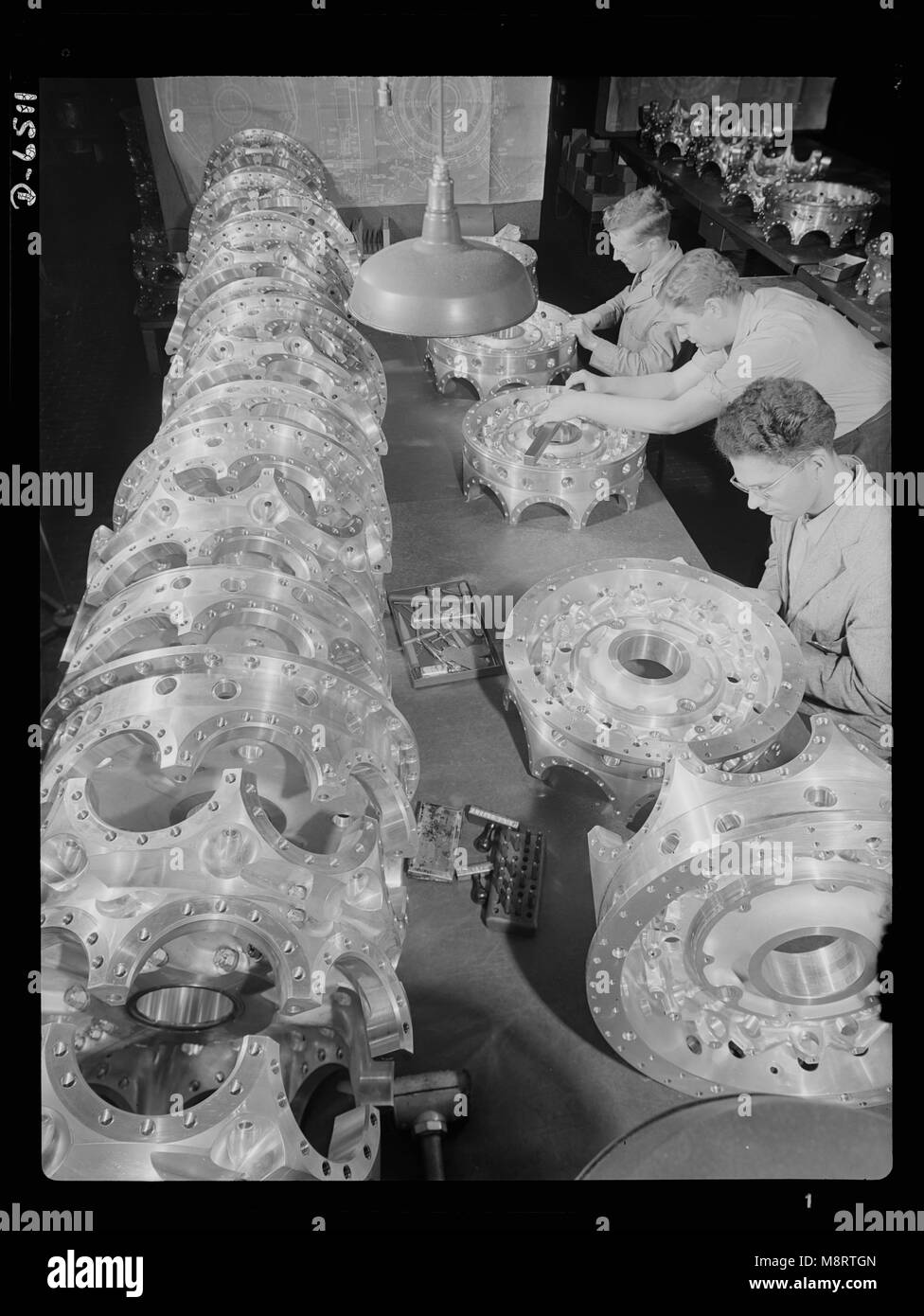 Three Workers Carefully Inspecting Power Section Crank Cases for ...