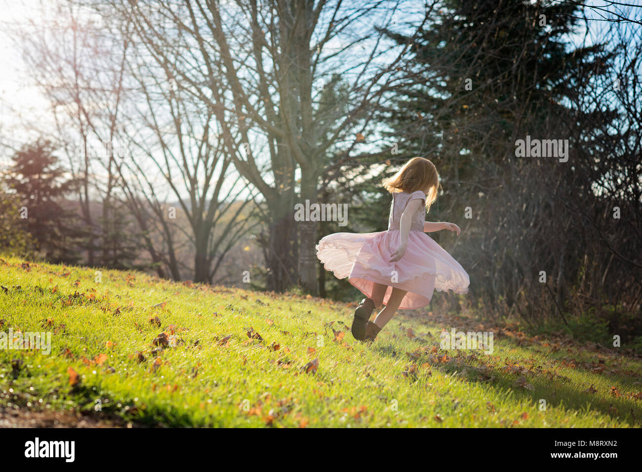 Full length of playful girl spinning on grassy field at park Stock ...