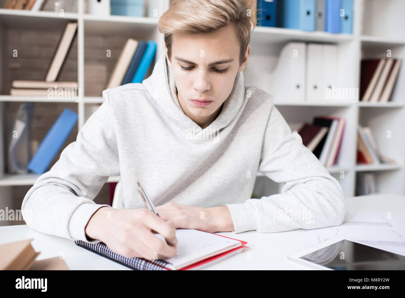 Teenage boy doing homework Stock Photo - Alamy