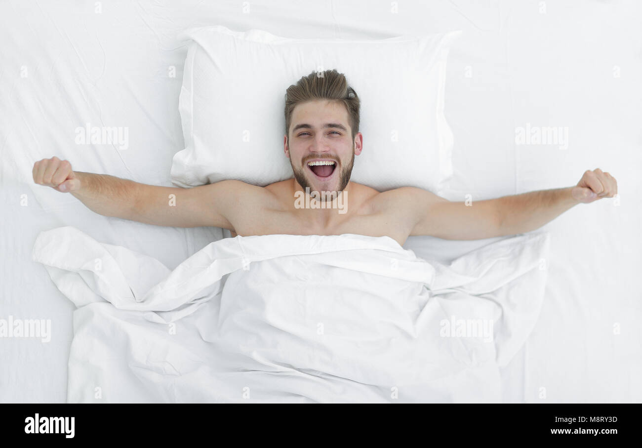 top view. happy man waking up in a comfortable bed Stock Photo - Alamy