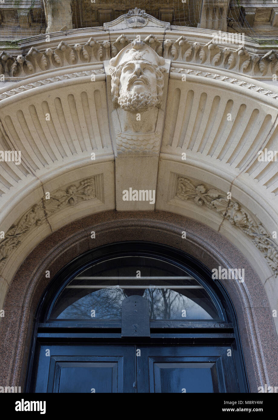Ribbed stone arch with grotesque head of plutus keystone in Old bank ...