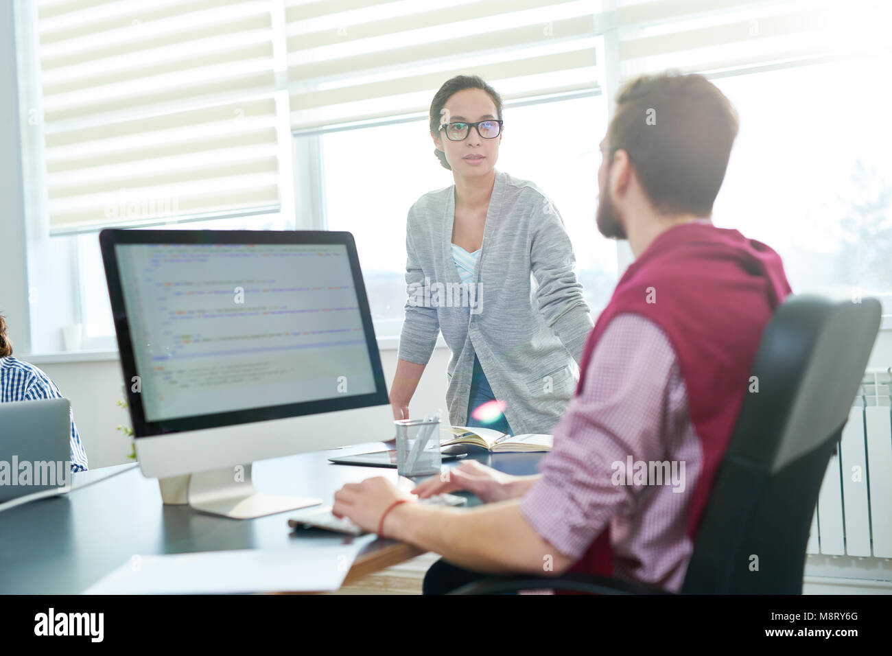 Coworkers talking in office Stock Photo - Alamy