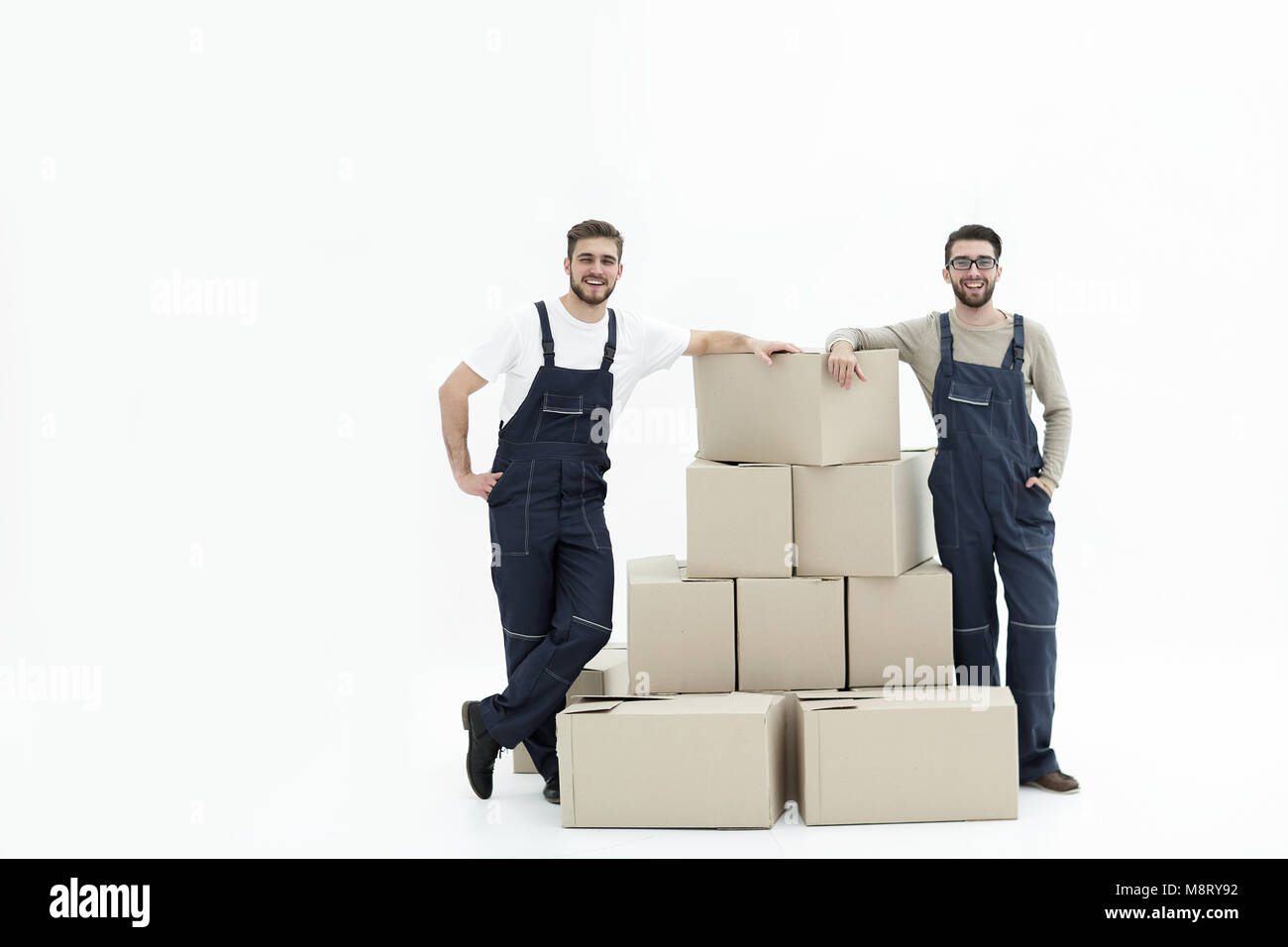 Young men carrying a box to the pile of boxes Stock Photo - Alamy