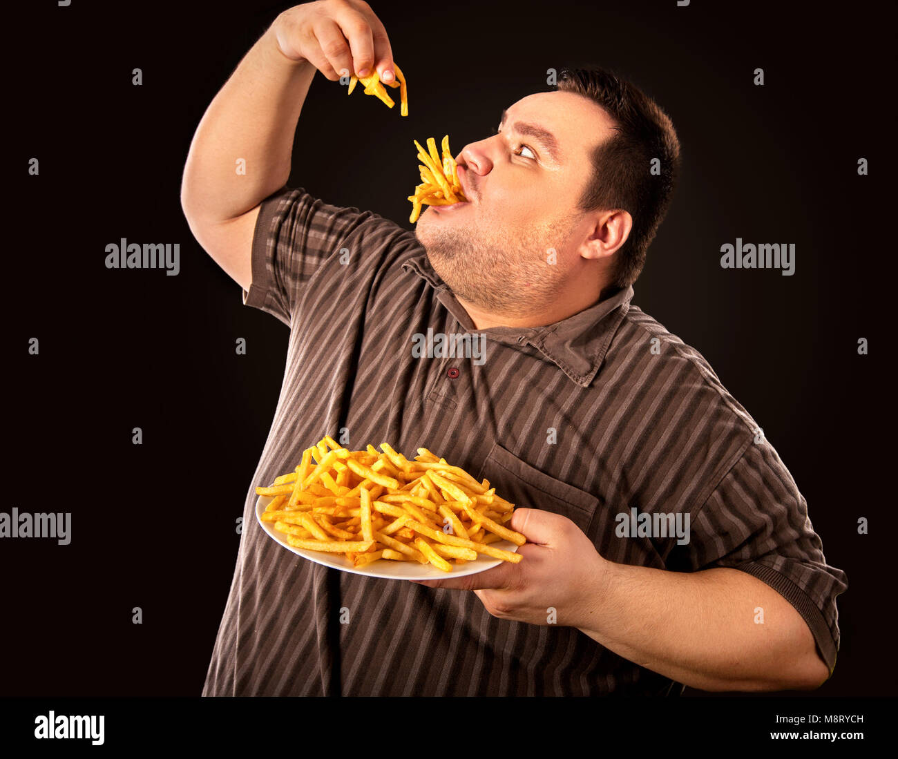 Fat man eating fast food french fries for overweight person Stock Photo ...