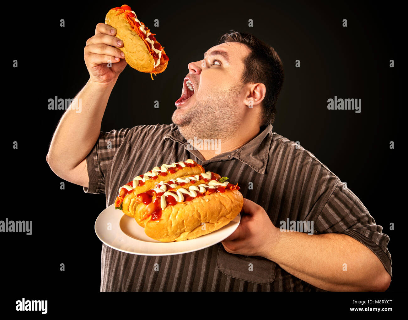 Fat man eating fast food hot dog. Breakfast for overweight person Stock ...