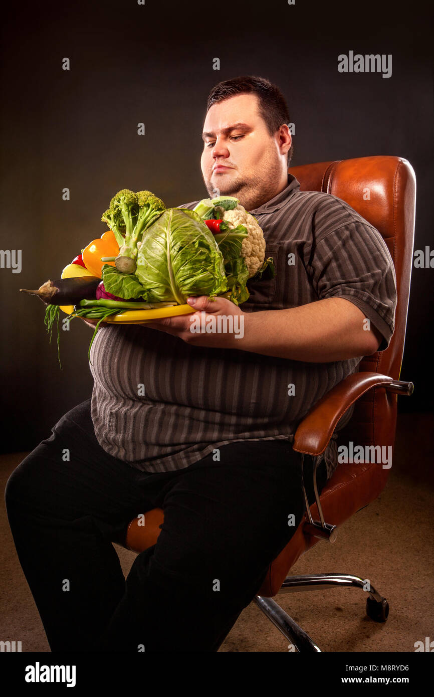 Diet fat man eating healthy food . Healthy breakfast with vegetables ...