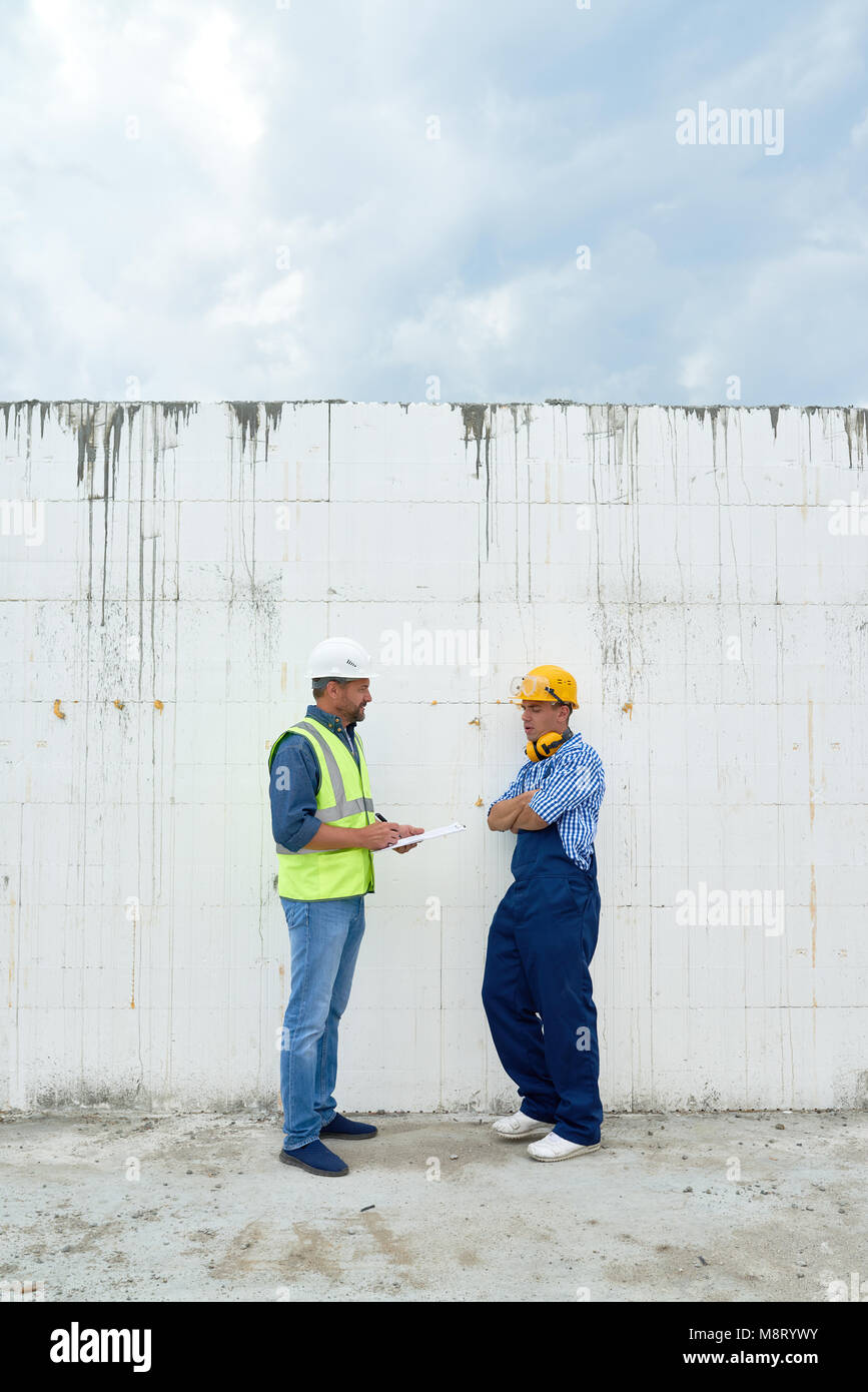 Two Construction Workers Discussing Building Stock Photo - Alamy