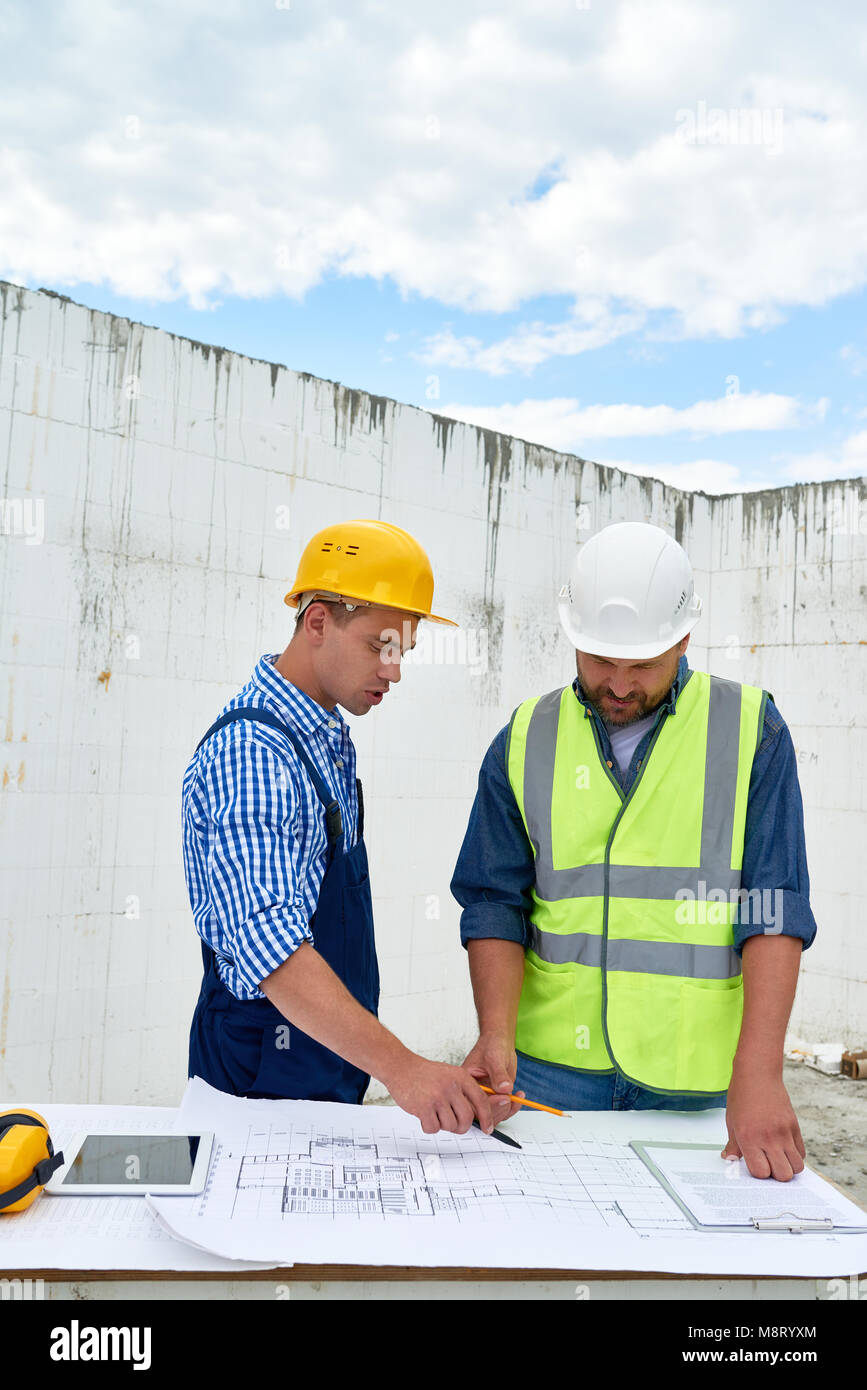 Builders Looking at Floor Plans on Construction Site Stock Photo - Alamy