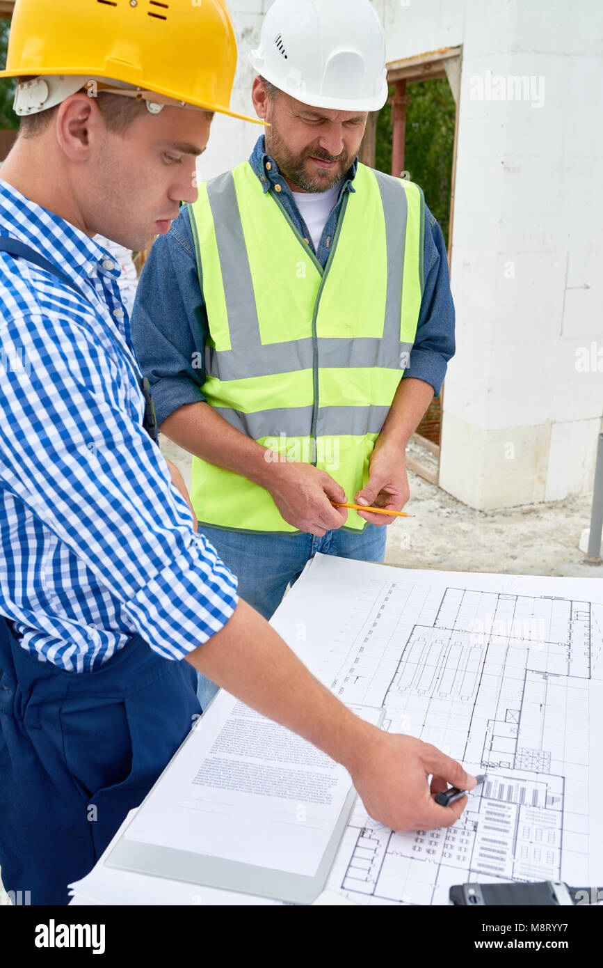 Builders Checking Floor Plans on Construction Site Stock Photo - Alamy