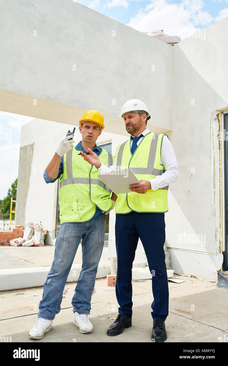 Construction Foreman Talking to Worker Stock Photo - Alamy