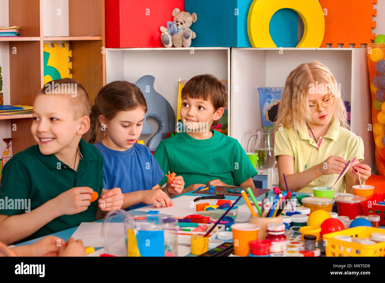 Plasticine modeling clay in children class. Teacher teaches in school ...