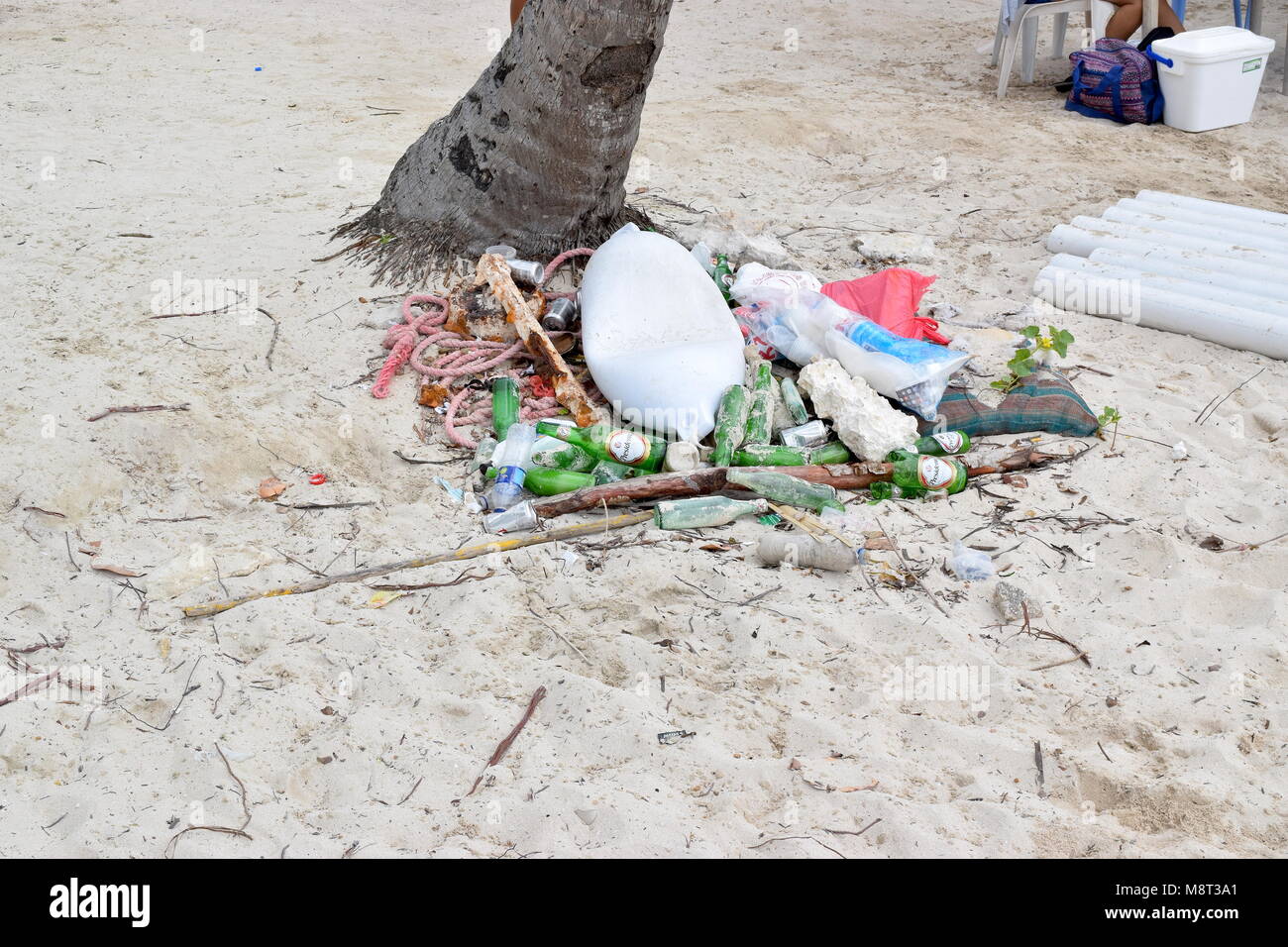 Pile of rubbish by a palm tree on sandy beach Stock Photo - Alamy