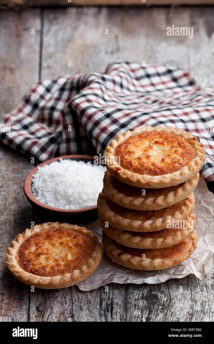 Stack of coconut tarts on wooden table Stock Photo - Alamy