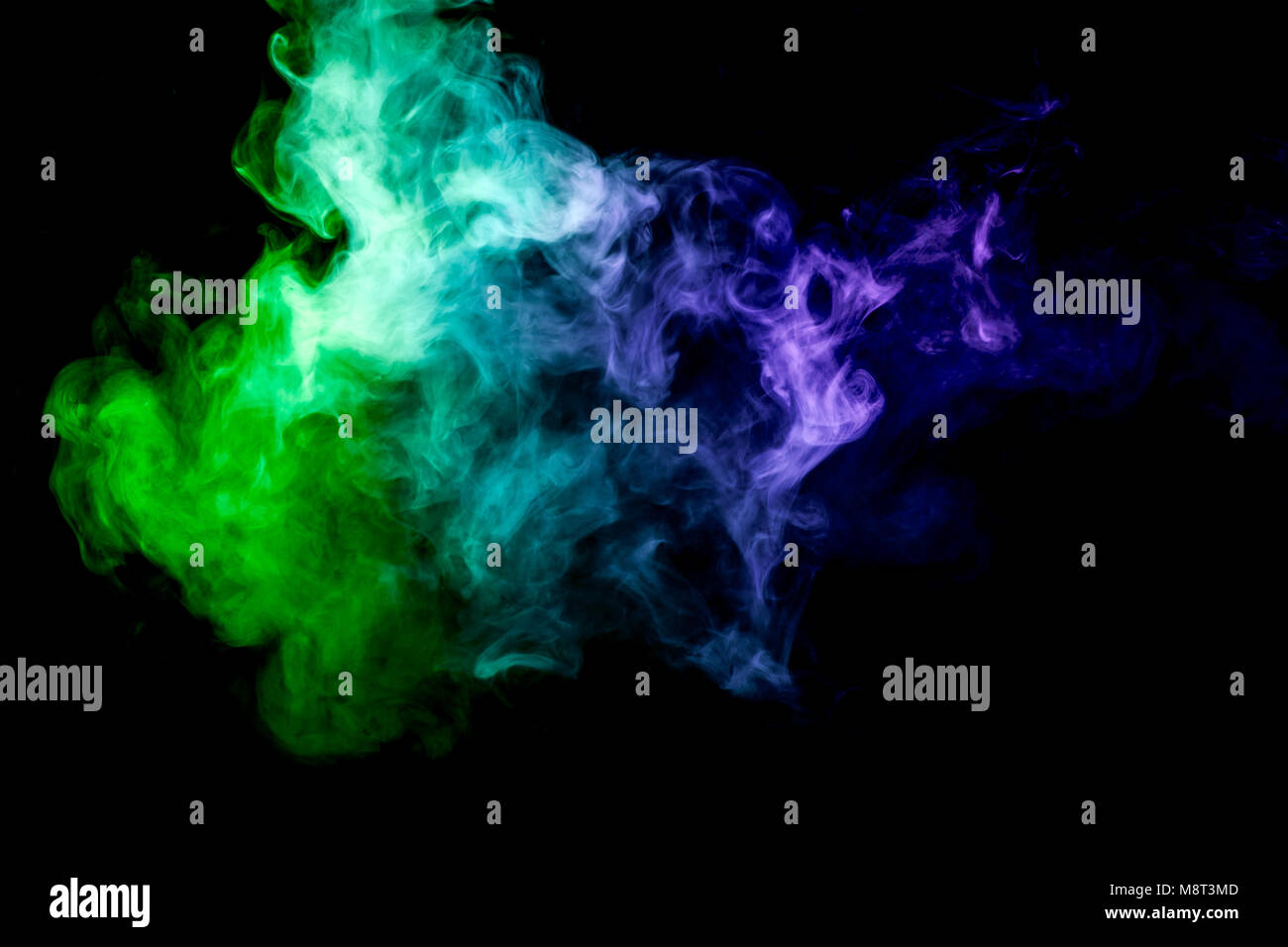 Dense multicolored smoke of blue, green colors on a black isolated ...