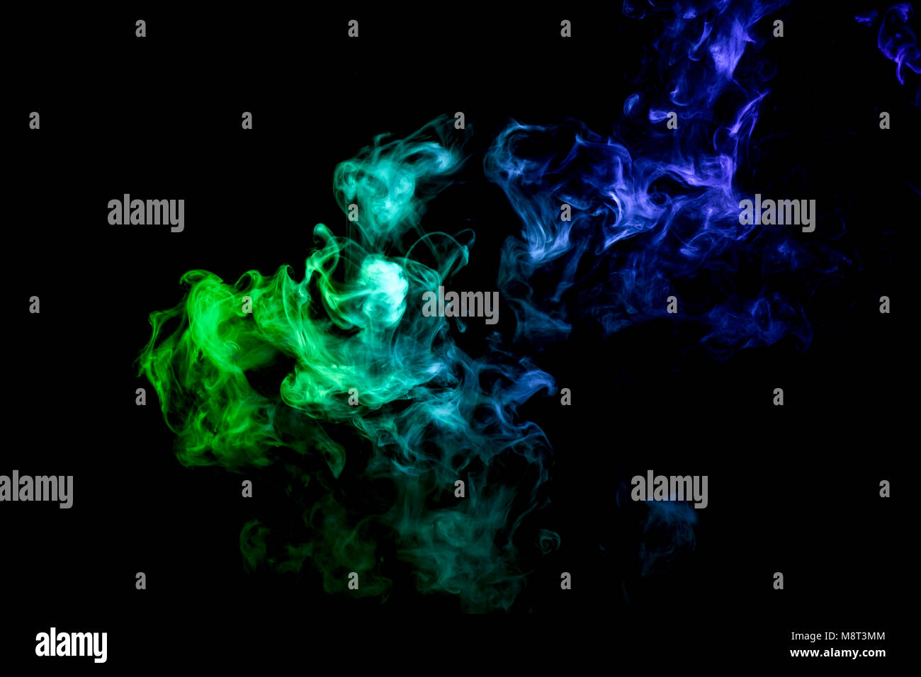 Dense multicolored smoke of blue, green colors on a black isolated ...