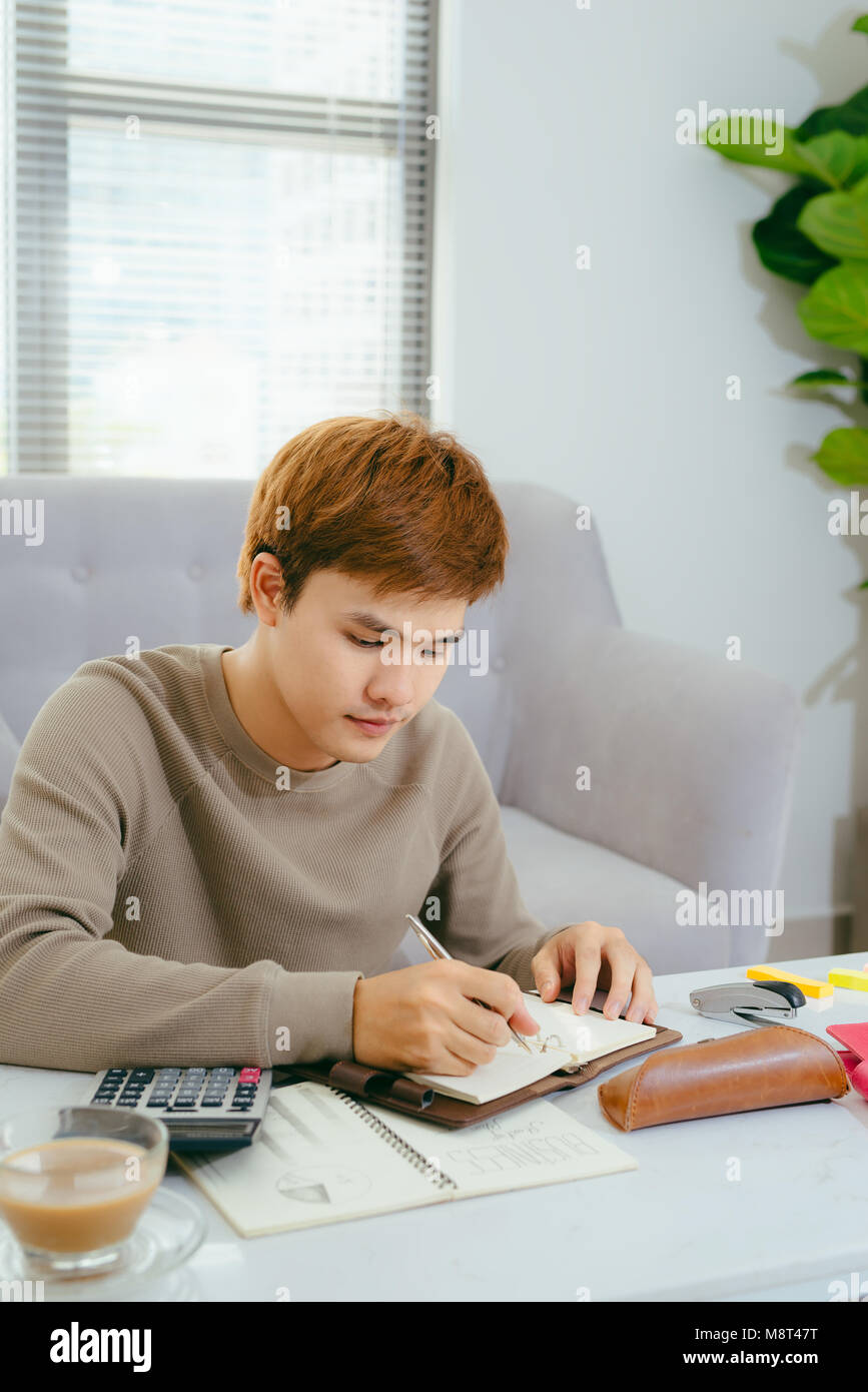 Asian man doing finances and calculate about cost at home office Stock ...