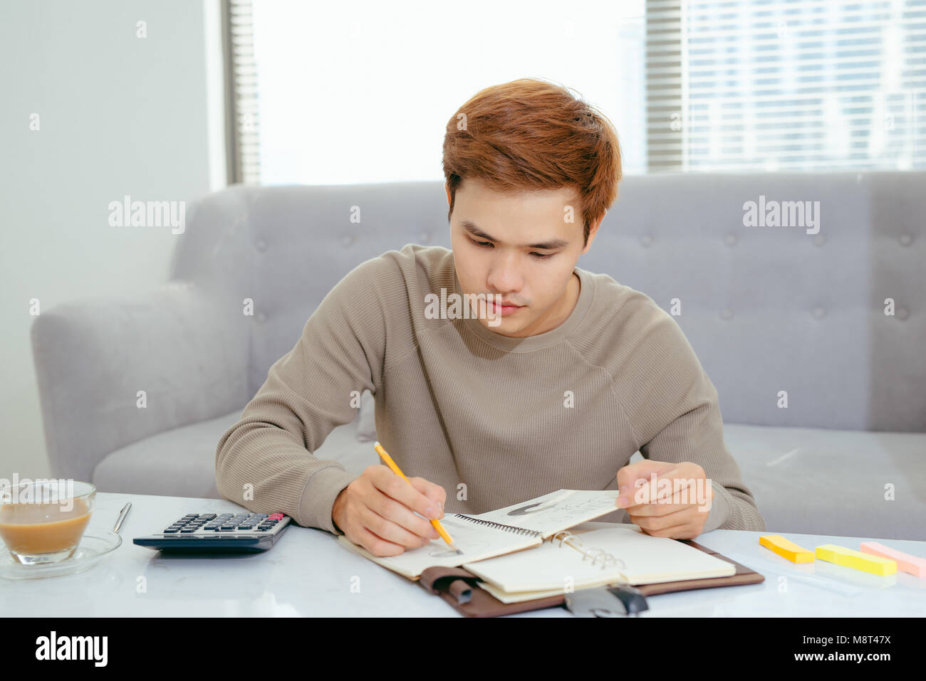 Asian man doing finances and calculate about cost at home office Stock ...