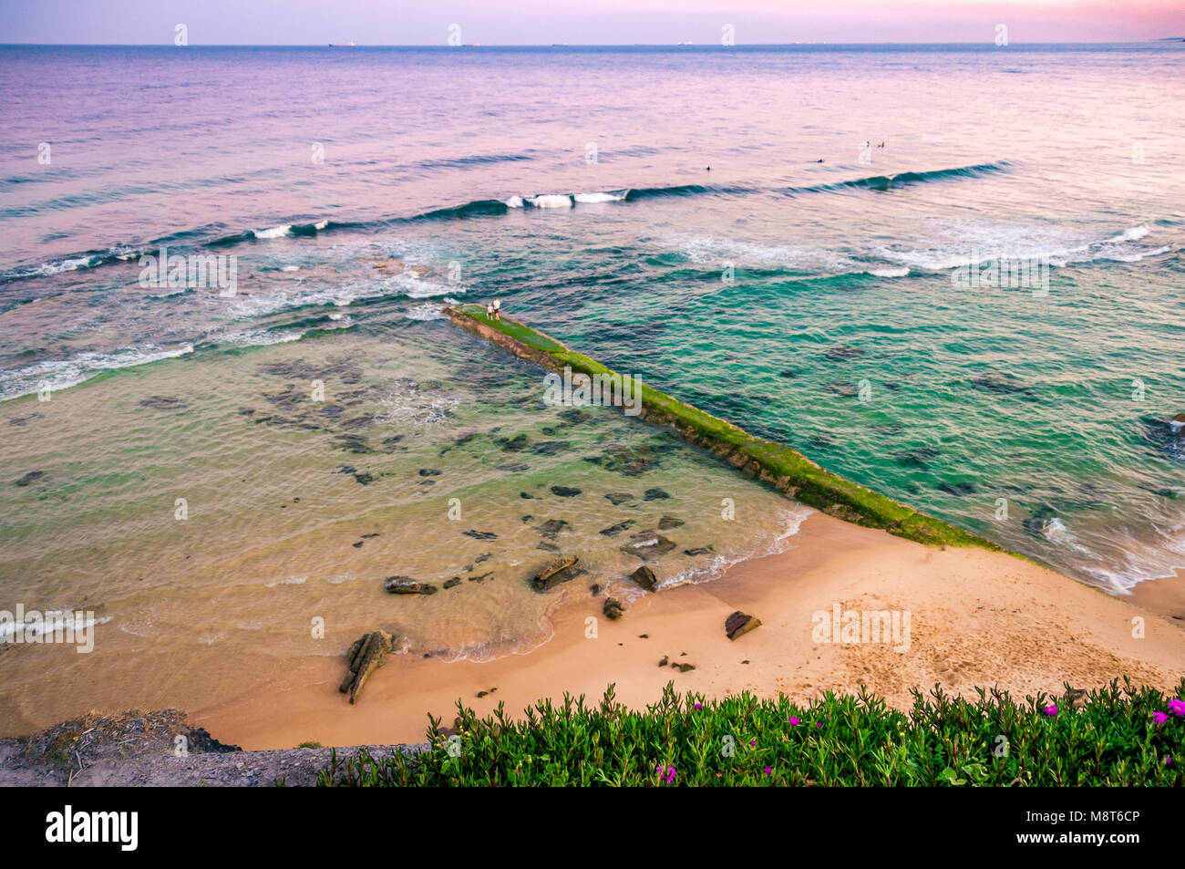 Sunrise over the ocean. Old stone pier overgrown with algae. Australia ...