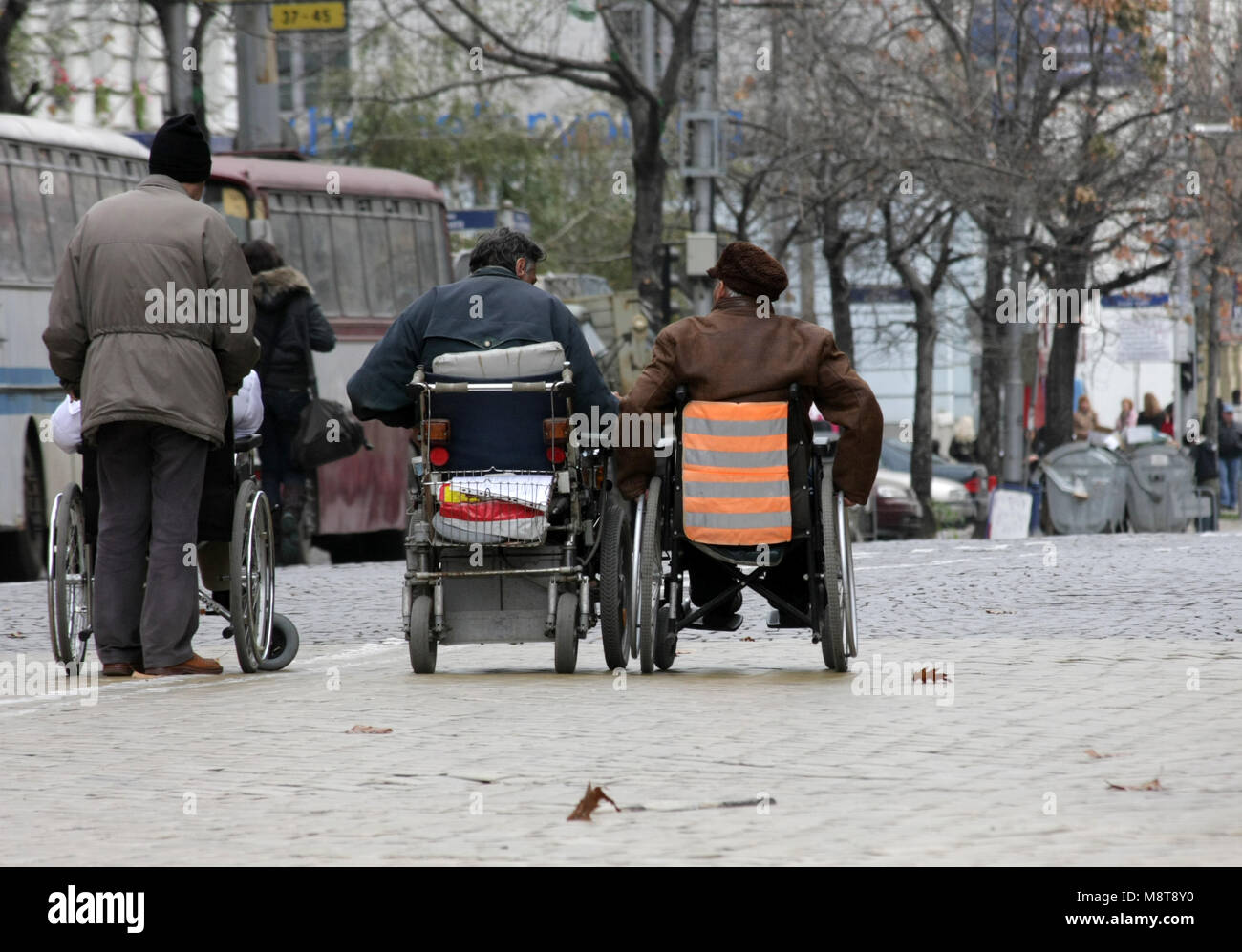 Handicapped people in wheelchairs on a street. Disabled person ...