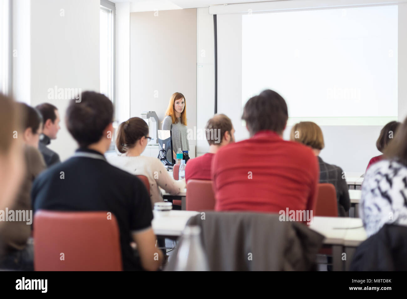Woman giving presentation in lecture hall at university Stock Photo - Alamy