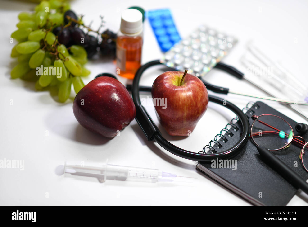 Apple,medicine, stethoscope and injections on a white background ...