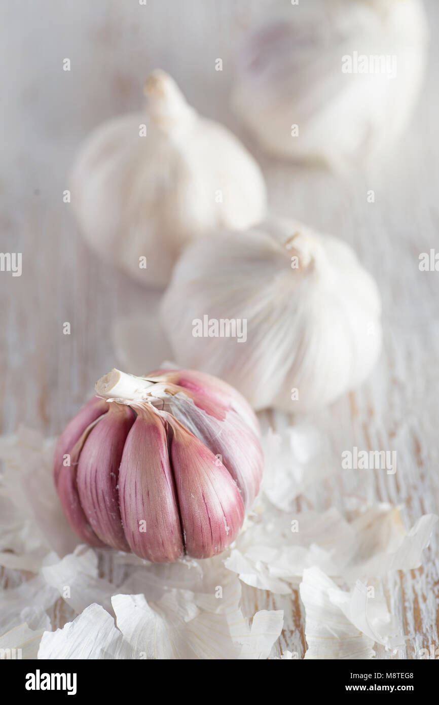 Group of garlics on white wood. Close-up Stock Photo - Alamy