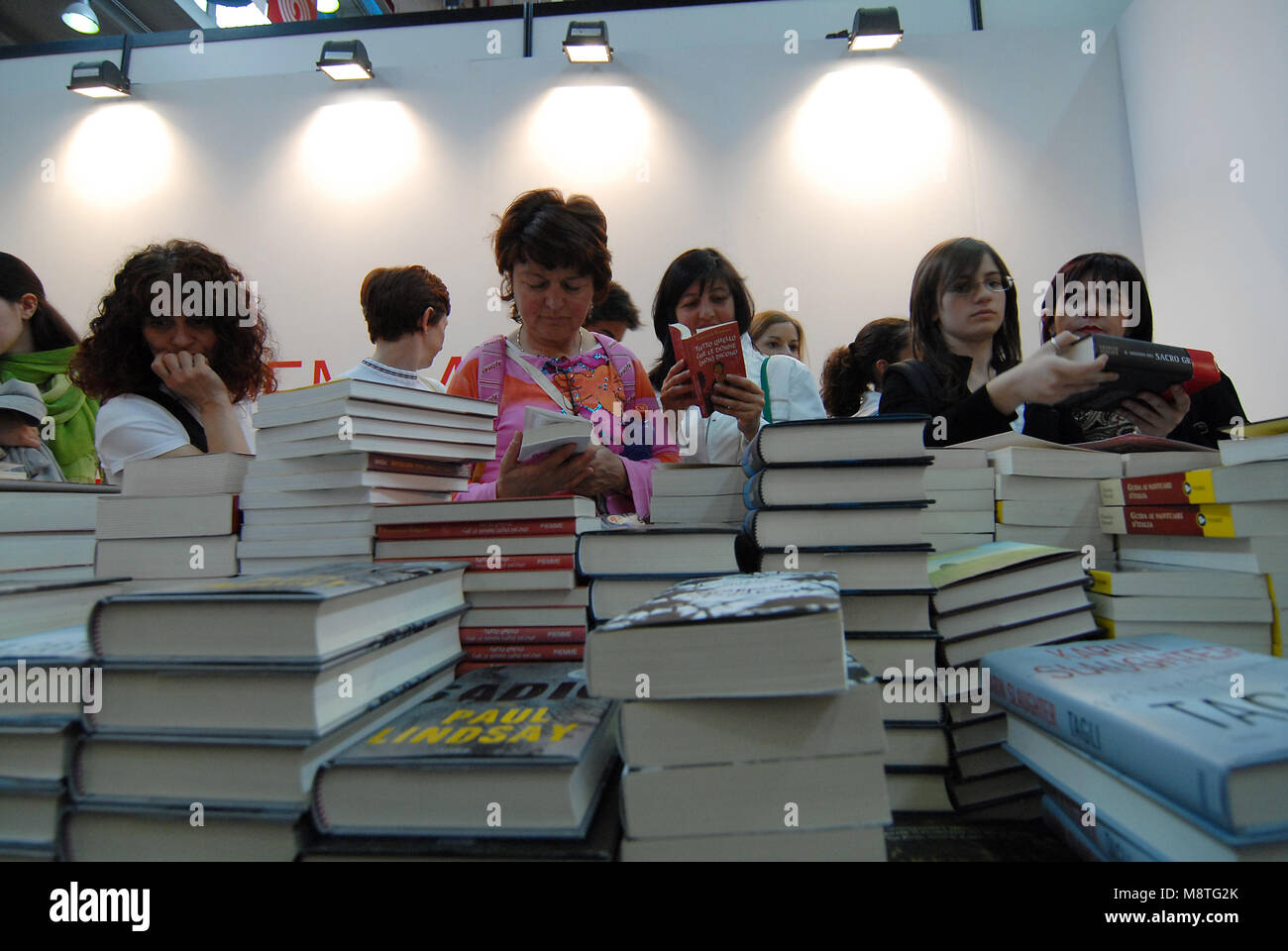 Reading book different aged women books piled in foreground Stock Photo ...