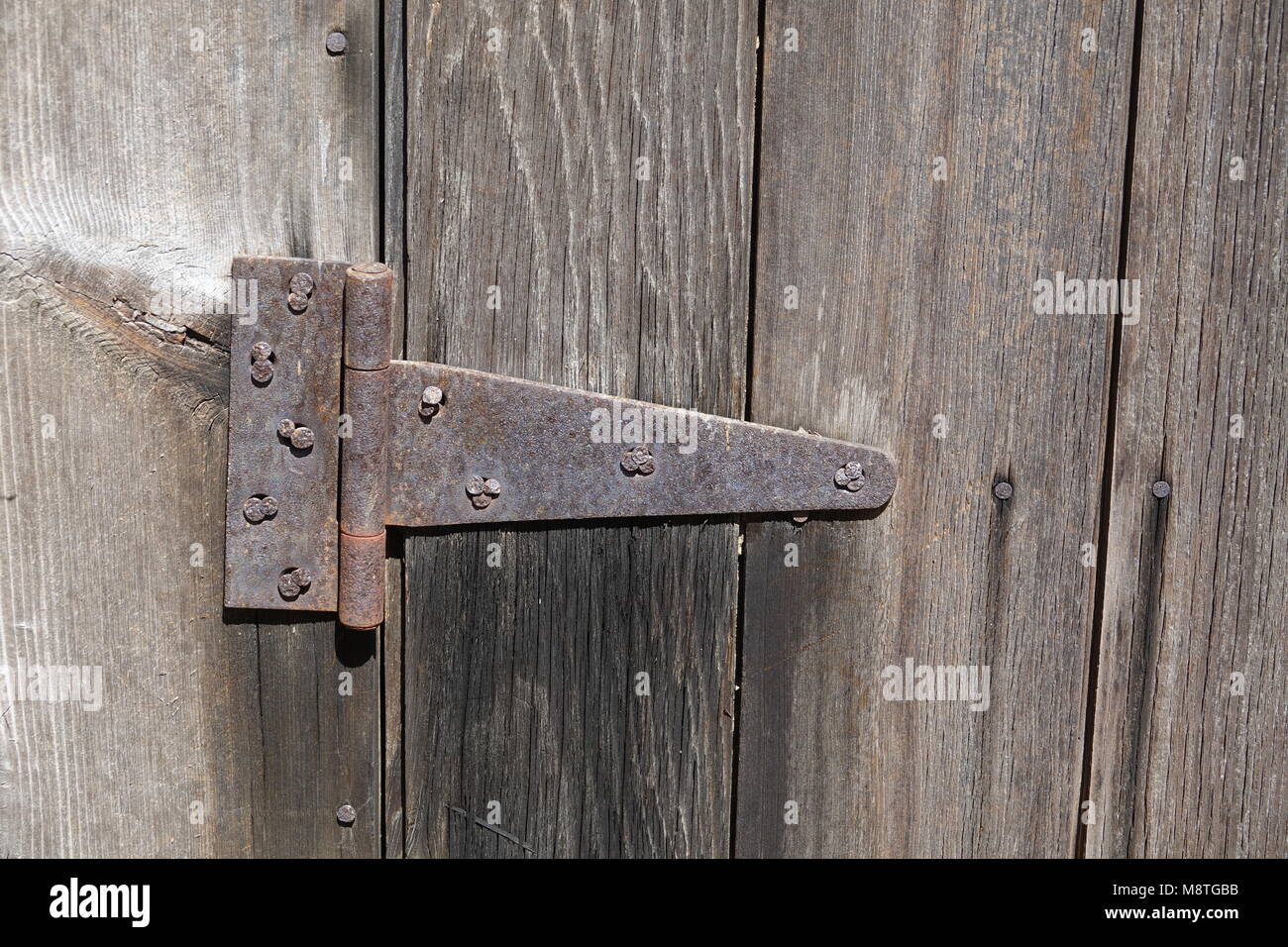 Rustic old farm building with rusty hinges, hasps and a pile of used ...