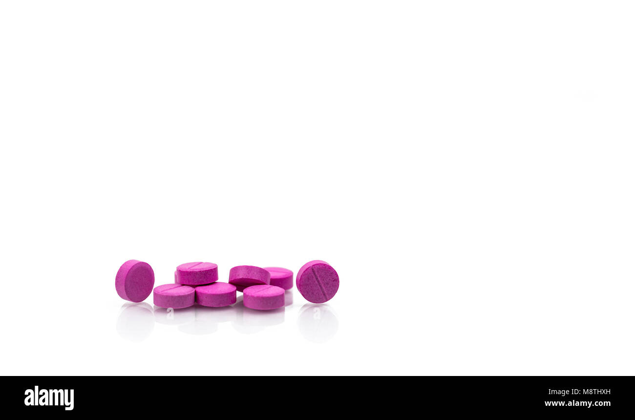 Pile of round pink small tablets pills isolated on white background ...