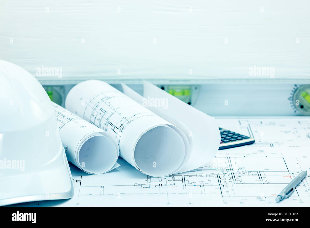 engineering plan, blueprint rolls, pencil, calculator, bubble level on ...