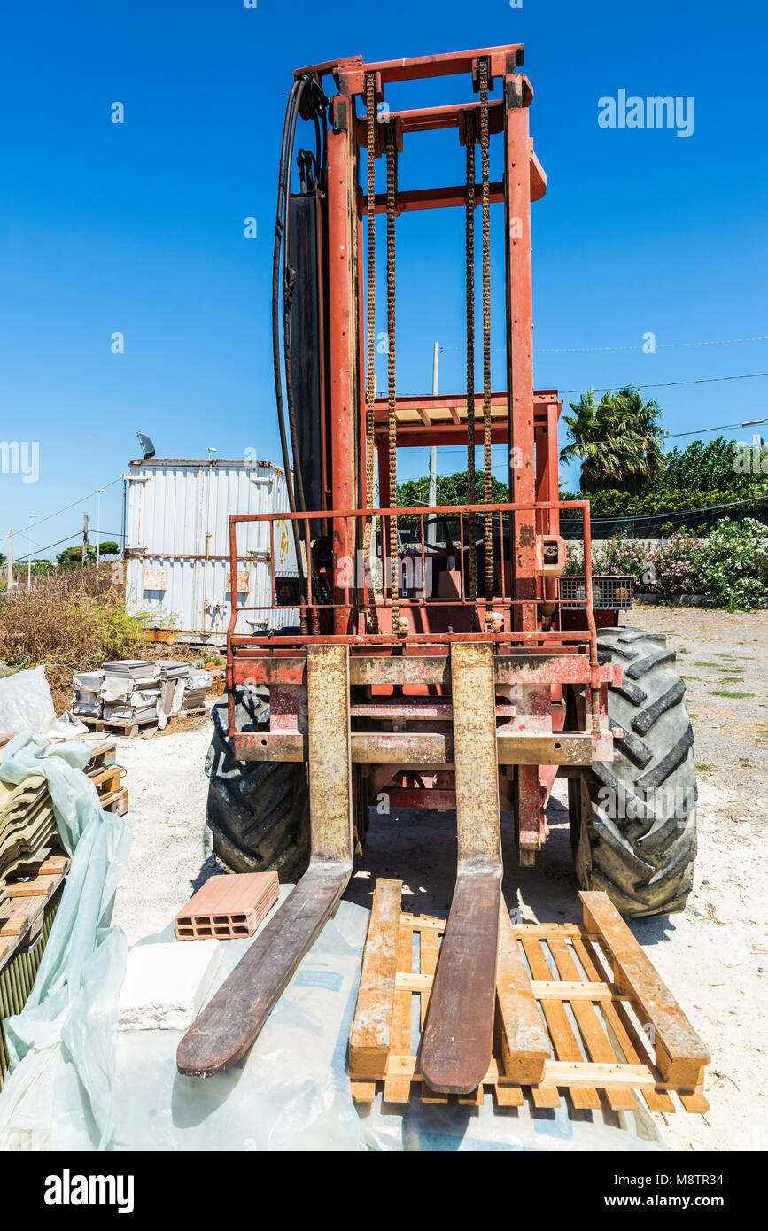 Old forklift in a construction site with construction materials and ...