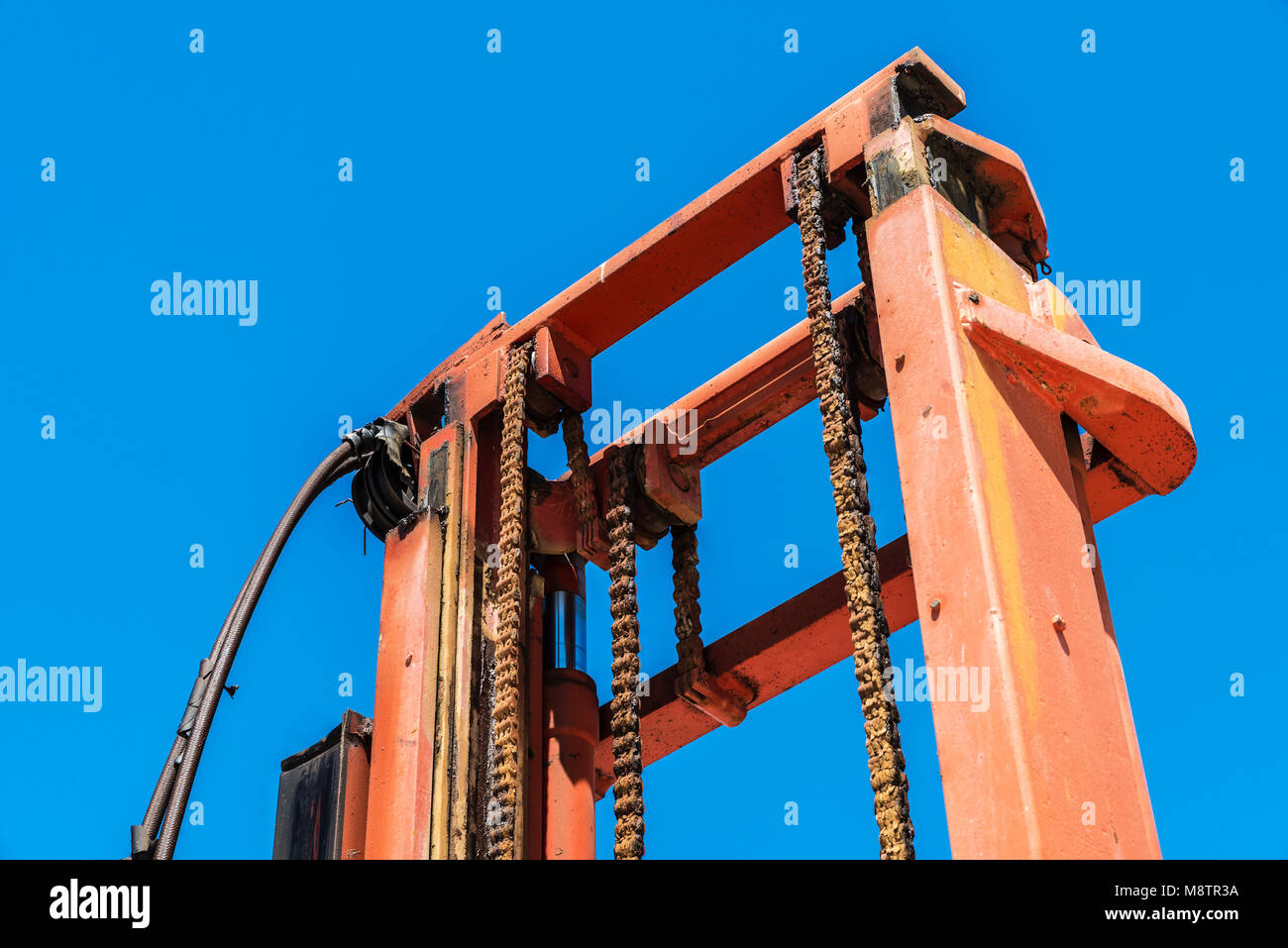 Chain gear of an old forklift in a construction site against the blue ...