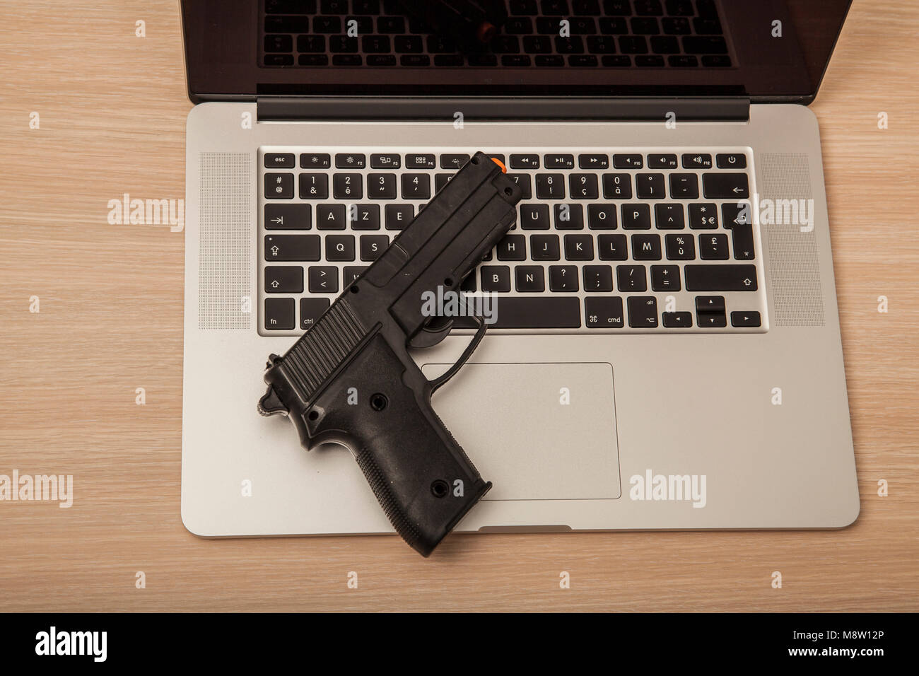Conceptual photo, weapon on a laptop as a symbol of organized crime ...